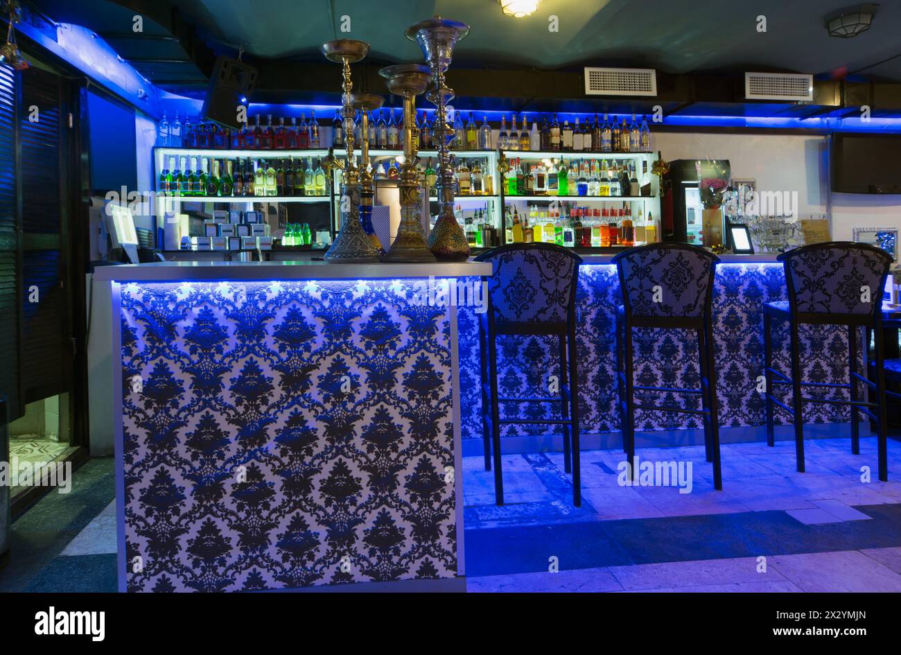 The bar counter with three chairs illuminated with blue light Stock Photo - Alamy