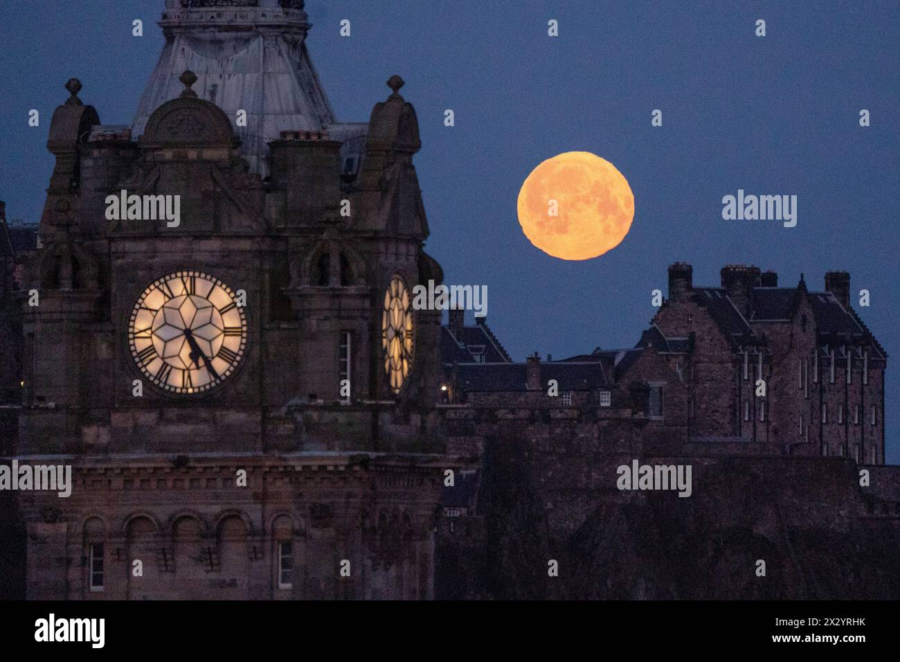 The full moon, which is known as the 'Pink Moon' during April, sets ...