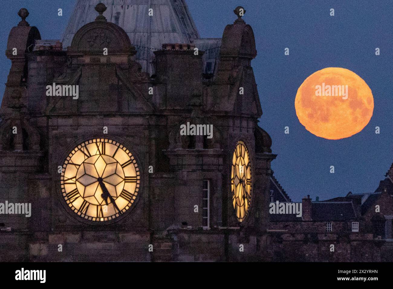 The full moon, which is known as the 'Pink Moon' during April, sets ...