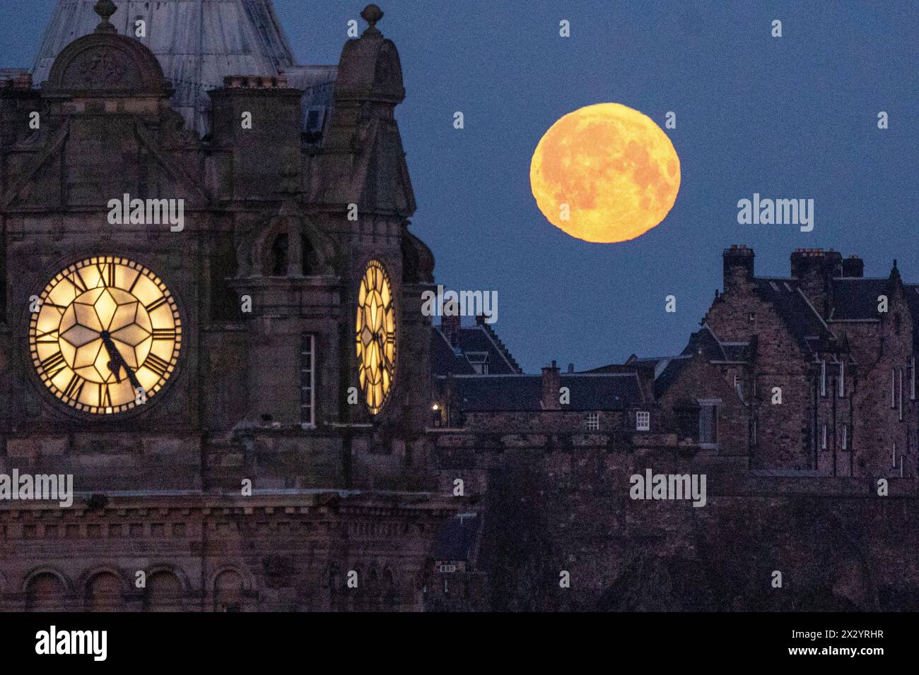 The full moon, which is known as the 'Pink Moon' during April, sets ...