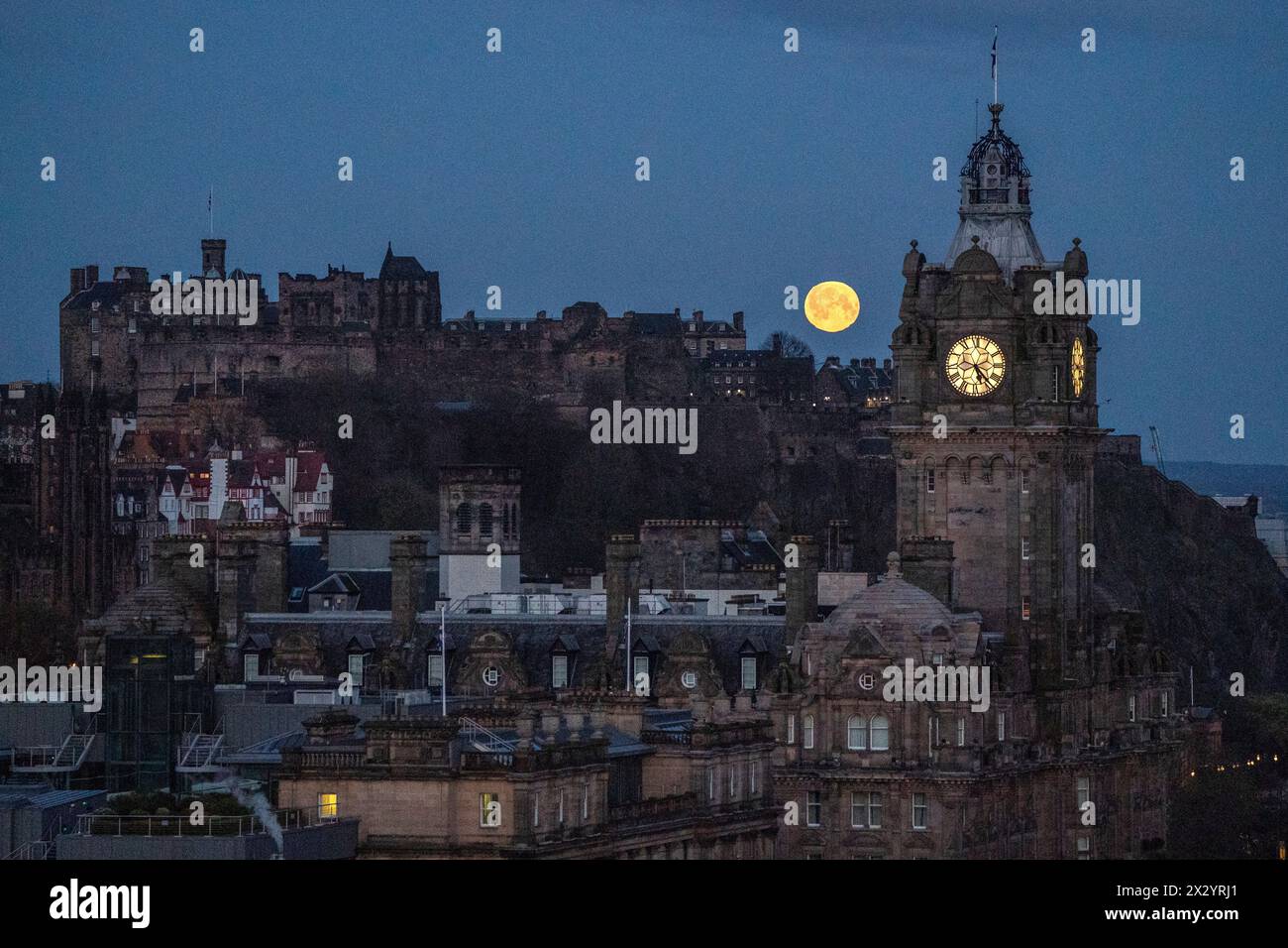 The full moon, which is known as the 'Pink Moon' during April, sets ...