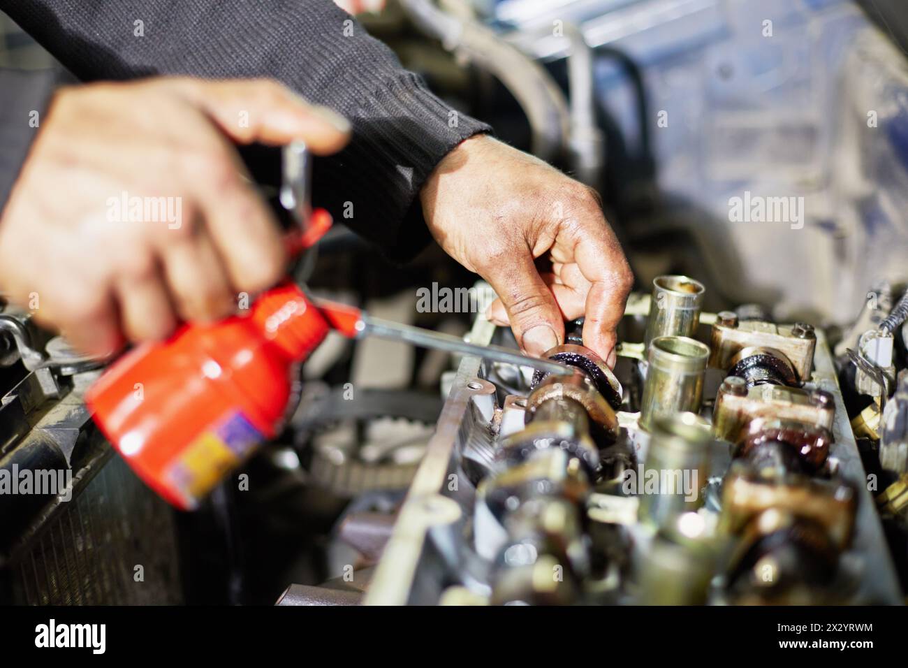 Hands of mechanic, who lubricates car engine Stock Photo - Alamy