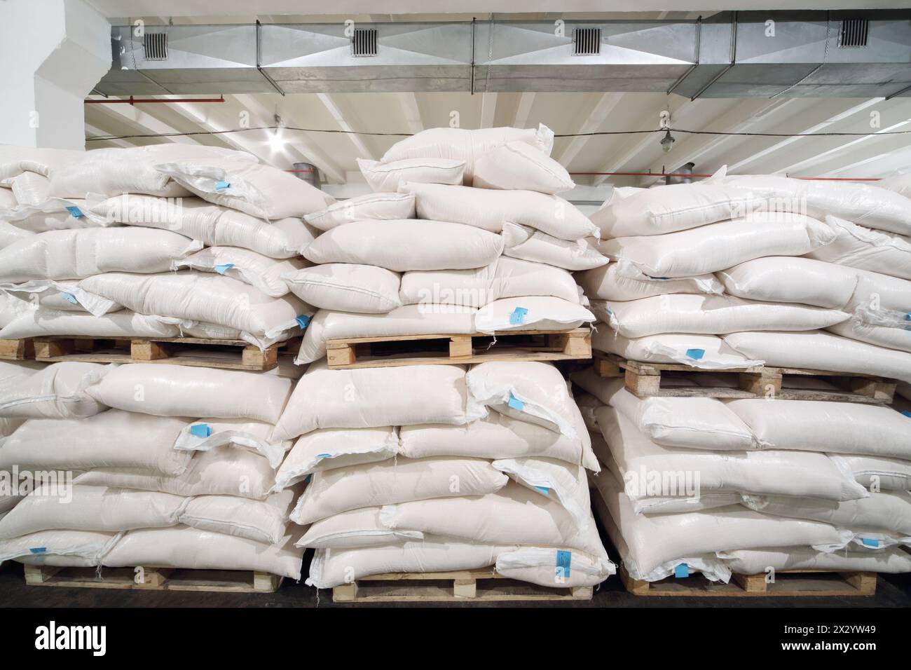 Rows of big white sacks at large warehouse in modern factory Stock ...