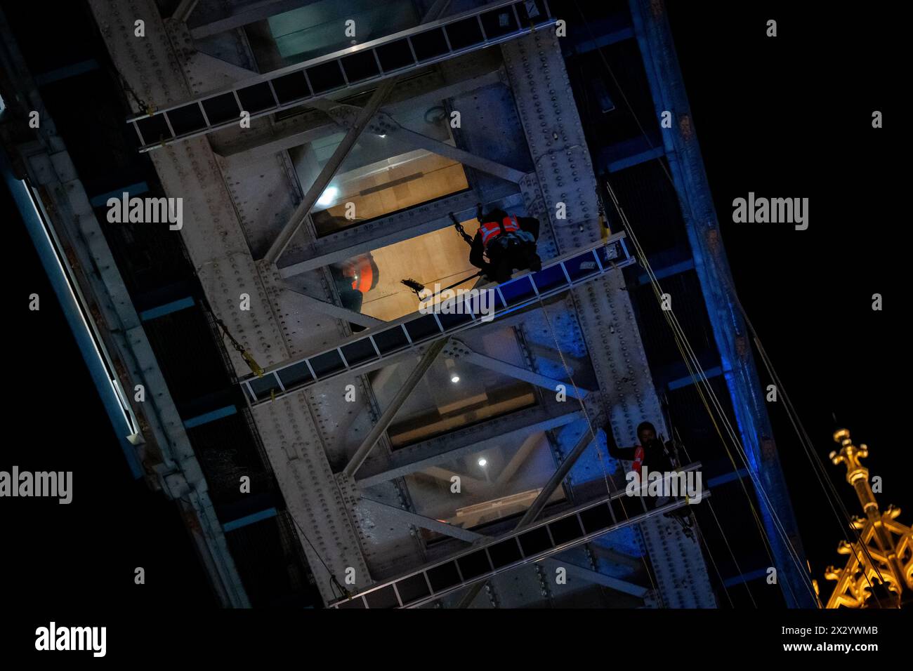 Rope access specialists hang from the underside of the walkways of ...