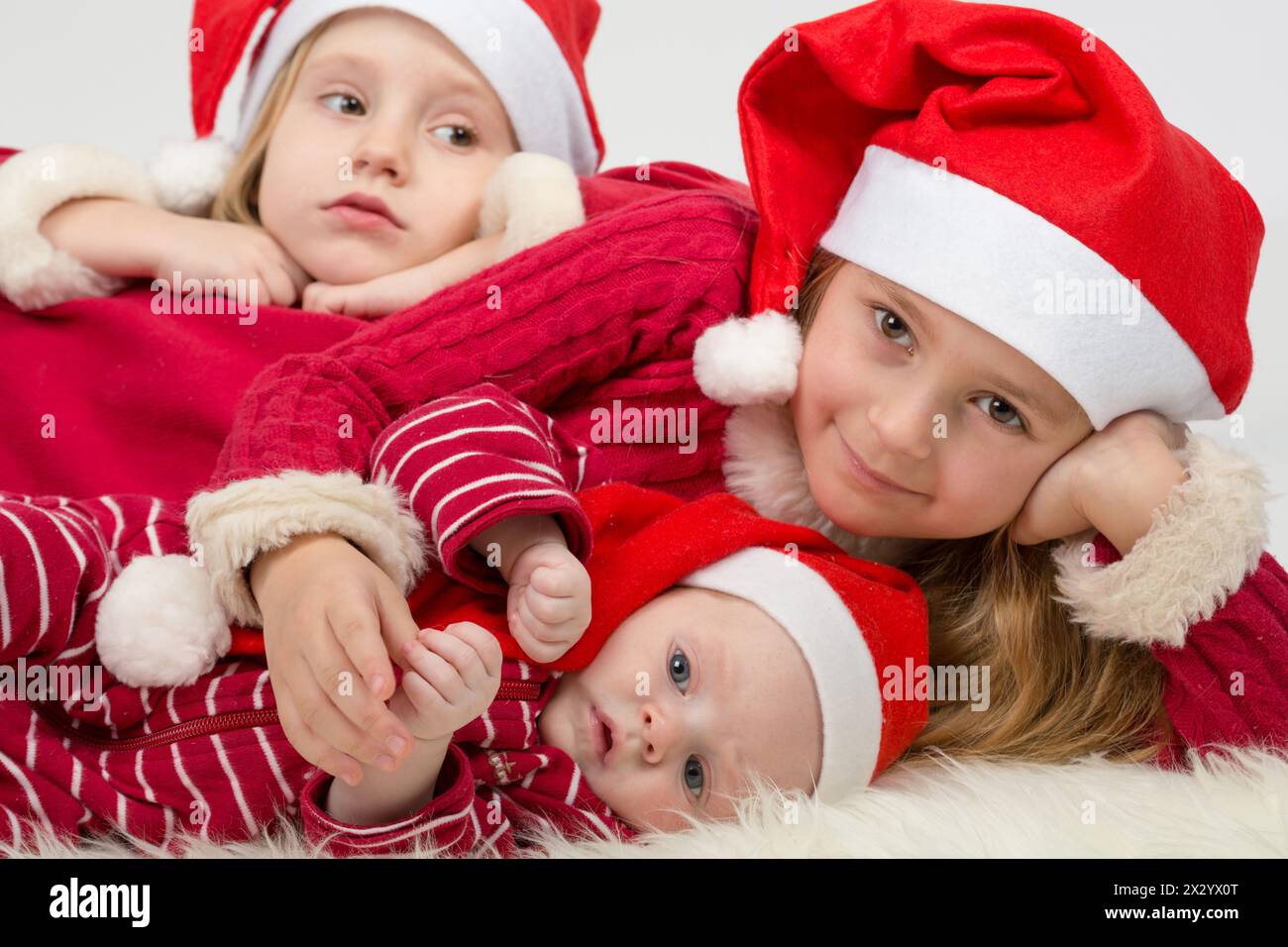 Three children lie in the hats of Santa Claus Stock Photo - Alamy