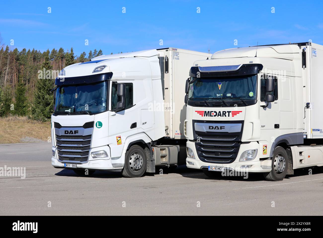 Two white DAF XF heavy trucks, 2021 generation vehicle left and ...