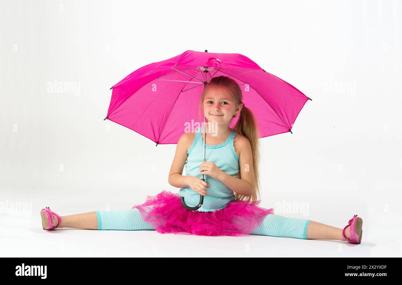 A girl with a pink umbrella do the splits on the floor Stock Photo - Alamy