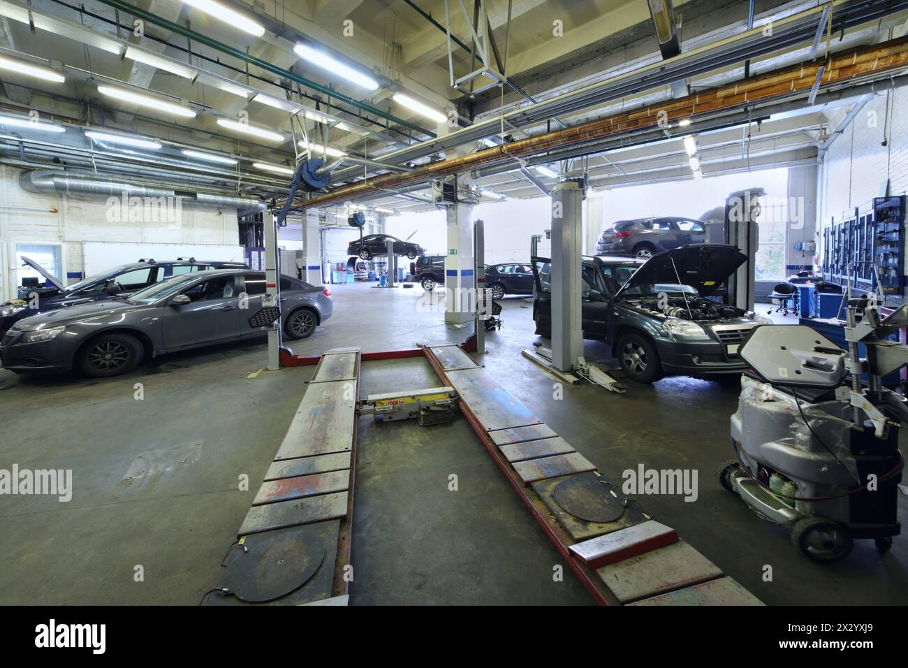 Many cars stand in car garage with special equipment for repair Stock ...