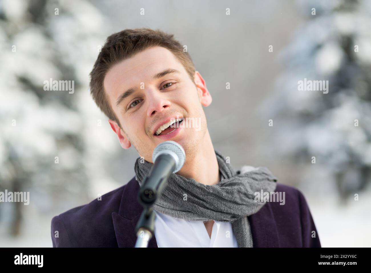 The singer in a suit and a scarf sing outdoors in winter Stock Photo ...