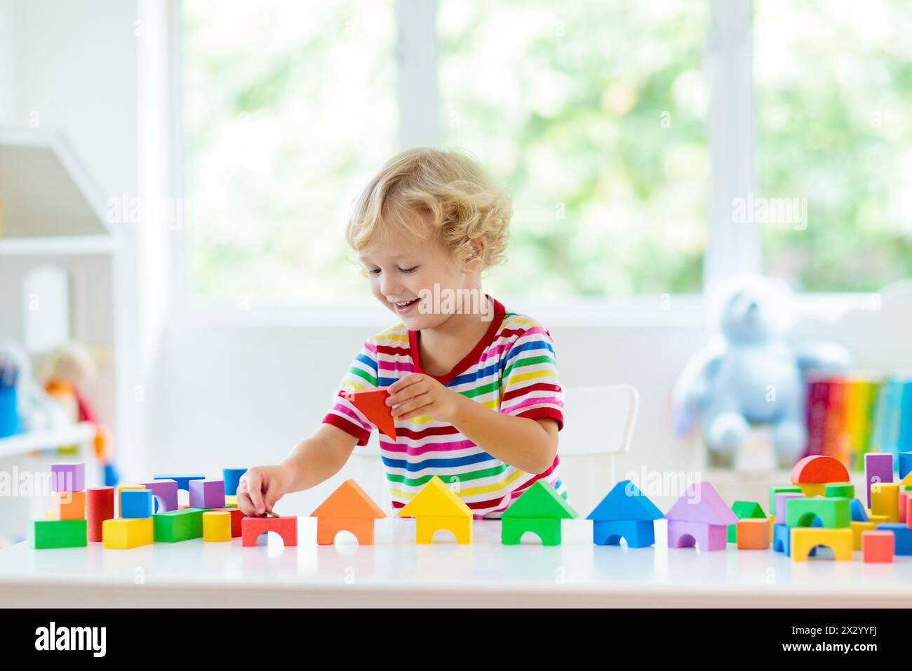 Kid playing with colorful toy blocks. Little boy building tower of ...