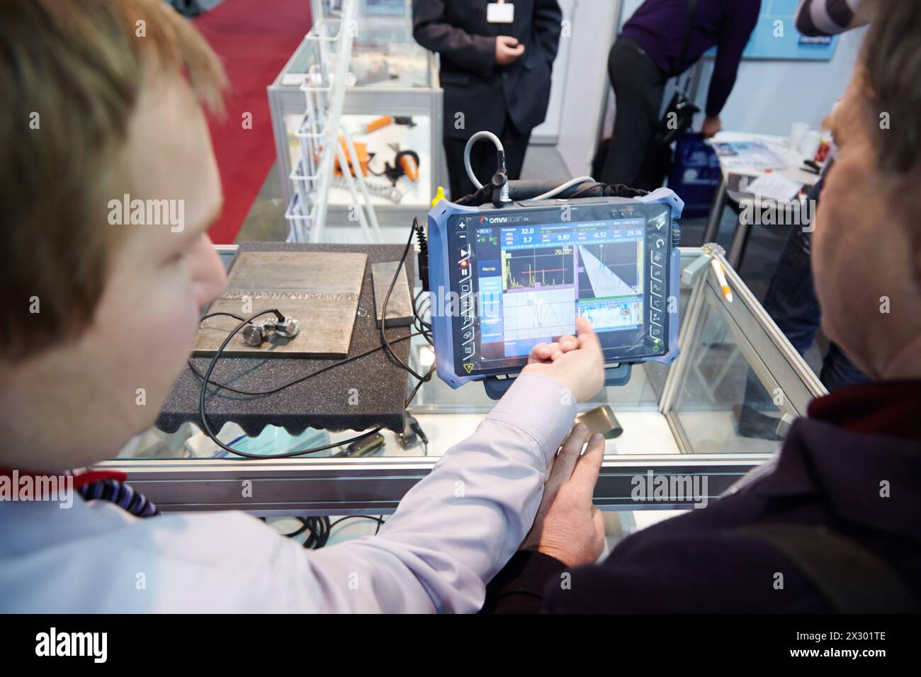 MOSCOW - FEB 28: Company representative explains operation of portable ...