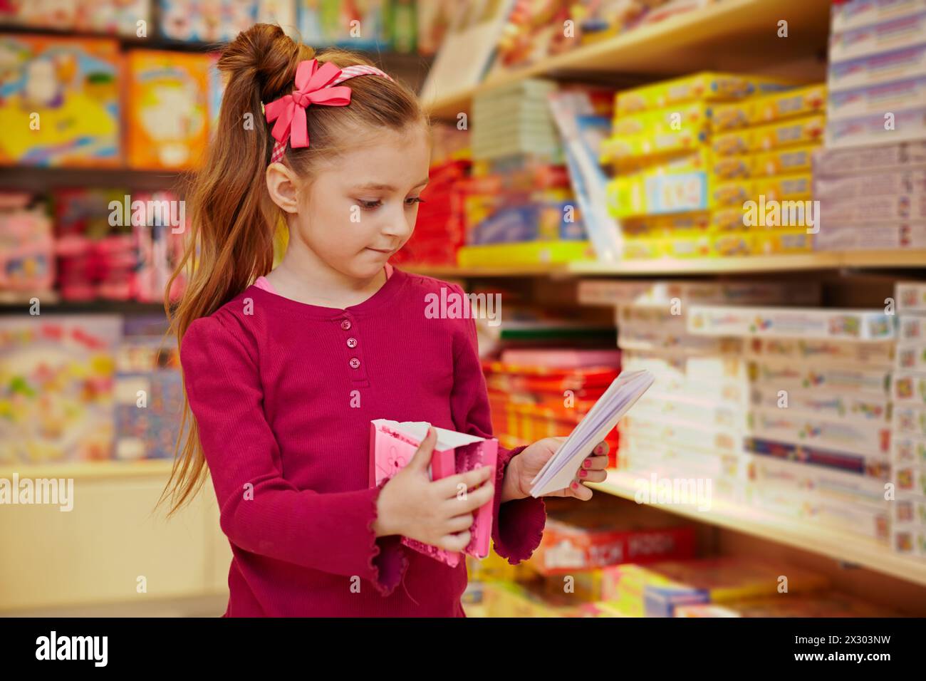 Little girl views pack of envelopes in book department of store Stock ...