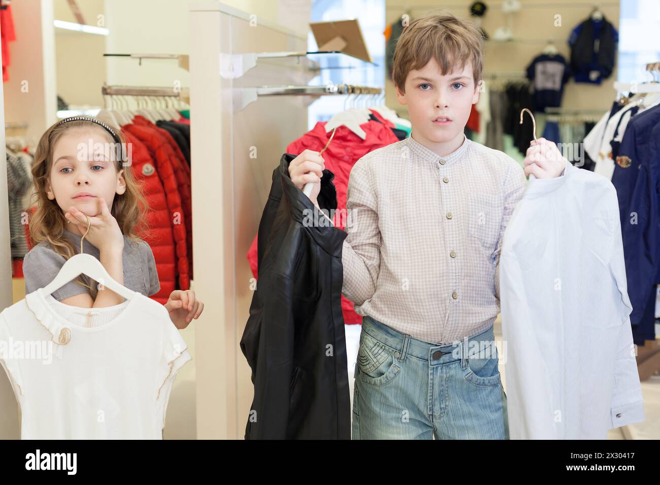 The boy with the girl trying on clothes in a store childrens clothes ...