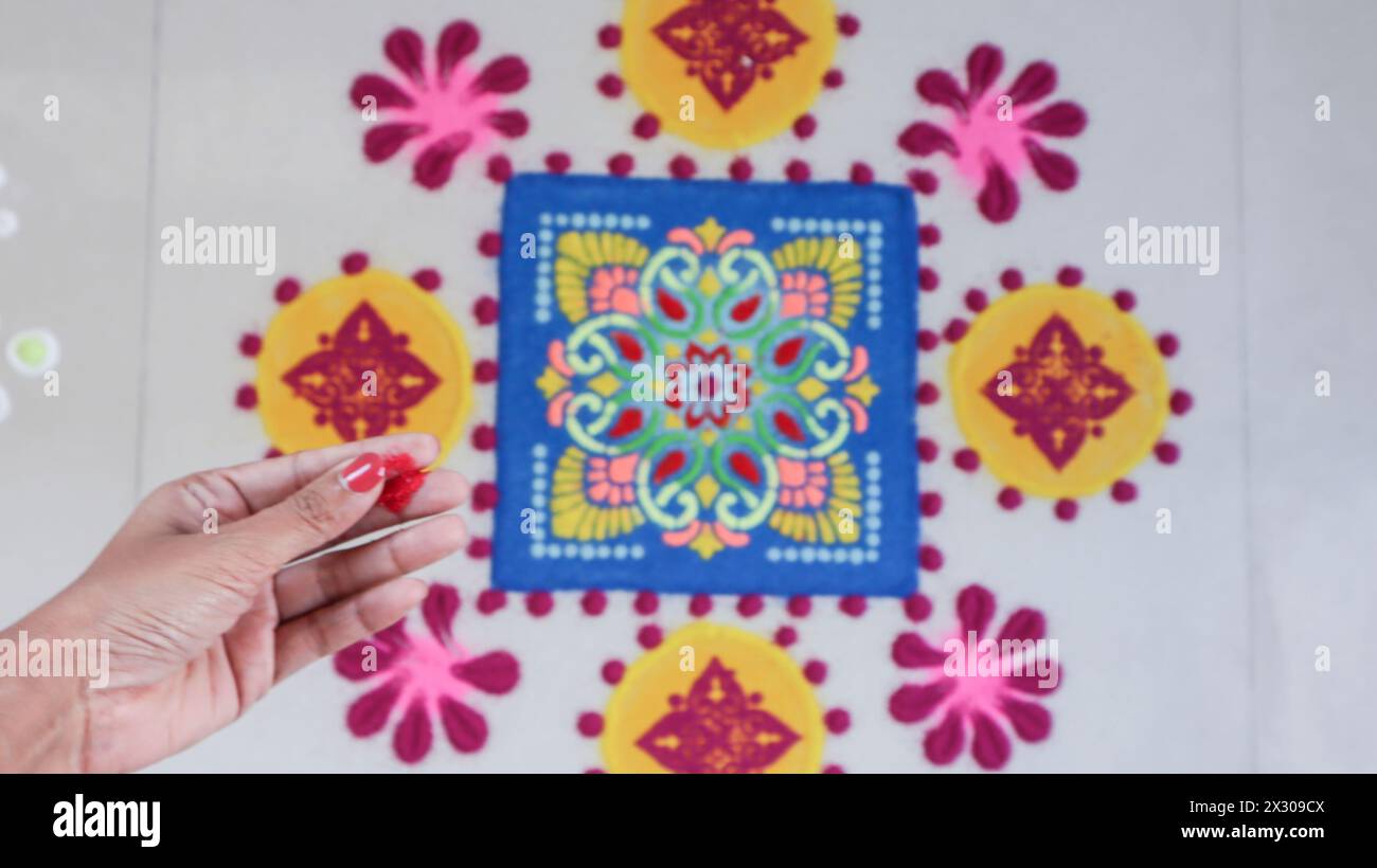 Female making beautiful Rangoli design. Rangoli making Stock Photo - Alamy