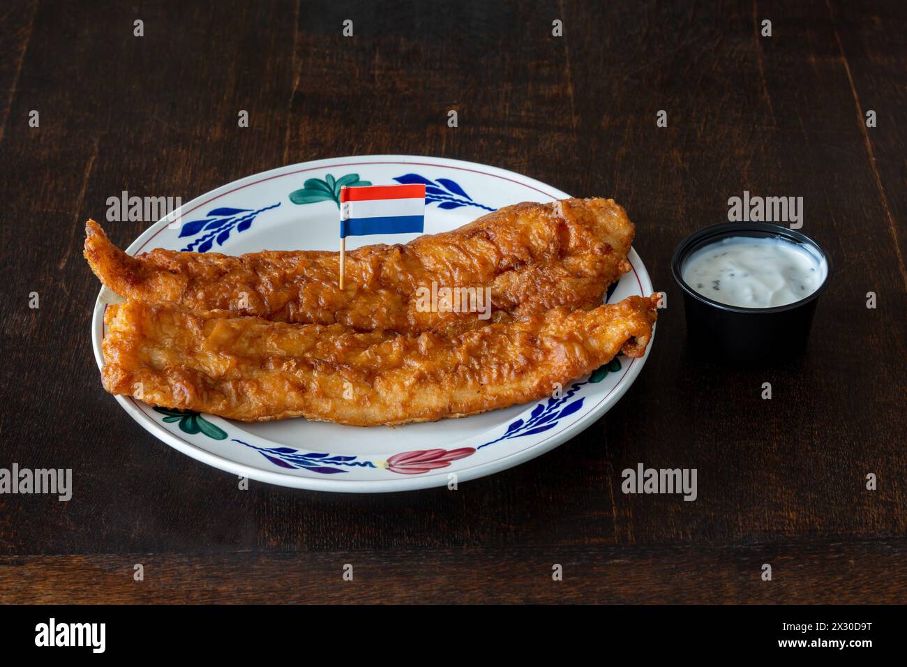 Lekkerbek with sauce on the plate decorated with dutch flag, deep fried ...