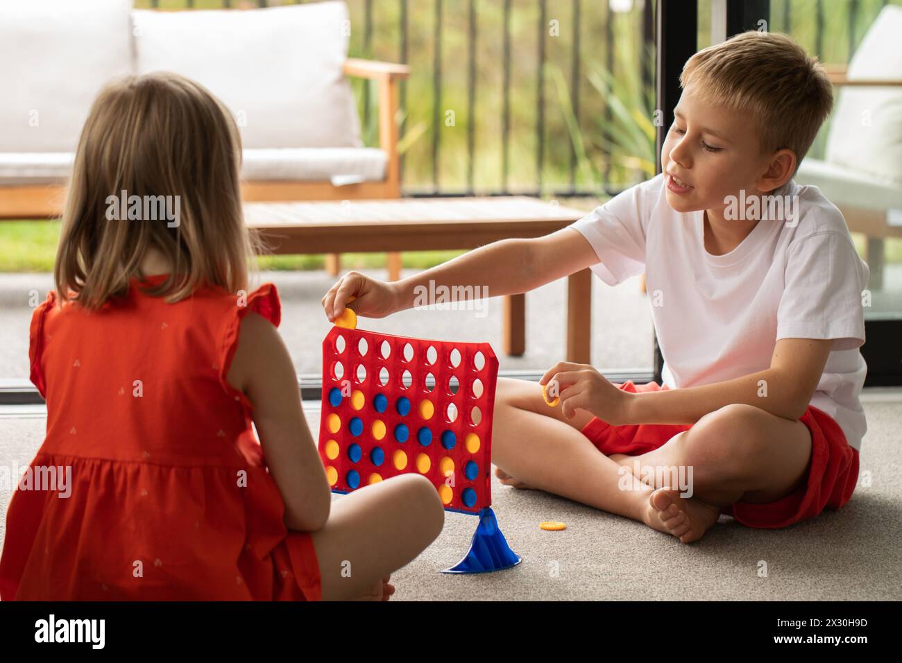 Siblings engrossed in a strategic board game, enhancing their logic ...