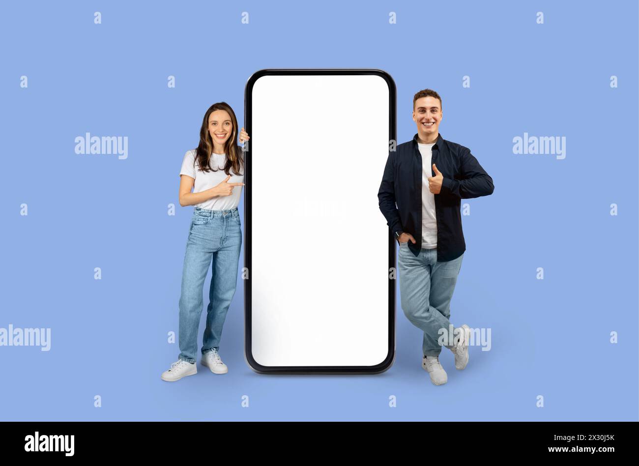 Pair presenting big smartphone with blank screen Stock Photo - Alamy