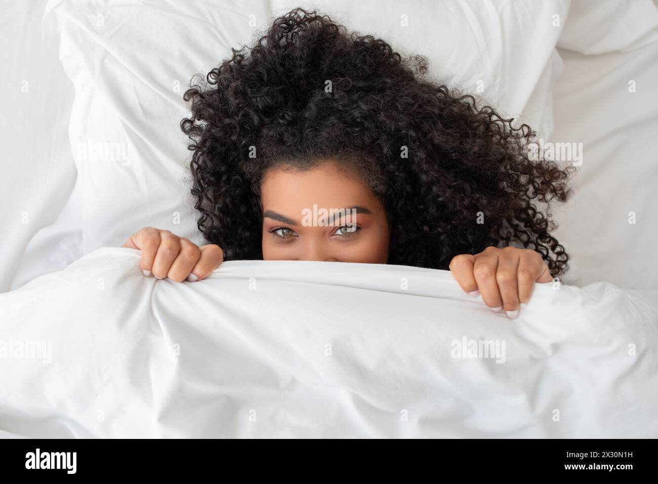 Woman Peeking Out From Under a Blanket Stock Photo - Alamy