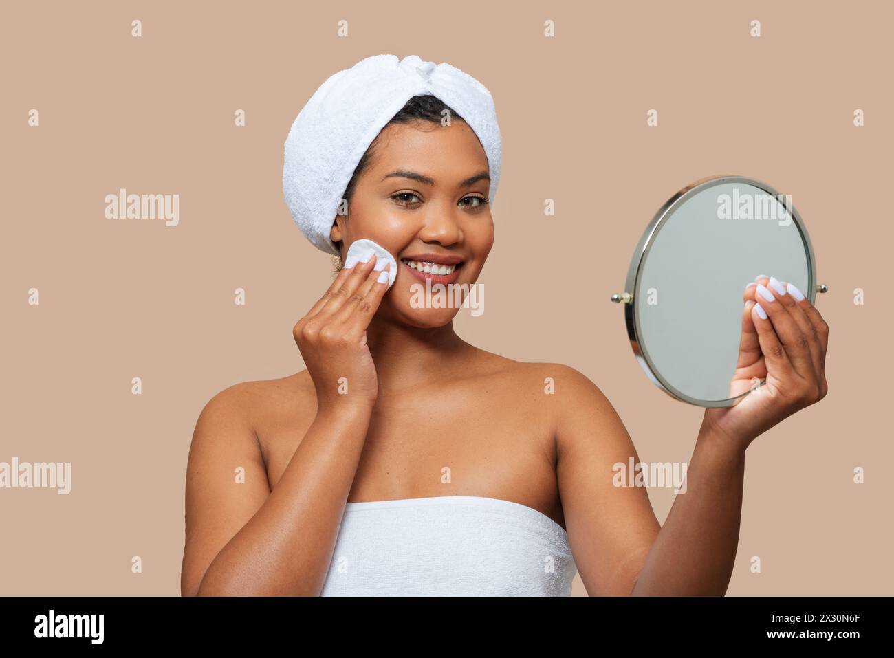 Young Woman Applying Facial Toner While Holding a Mirror Stock Photo ...
