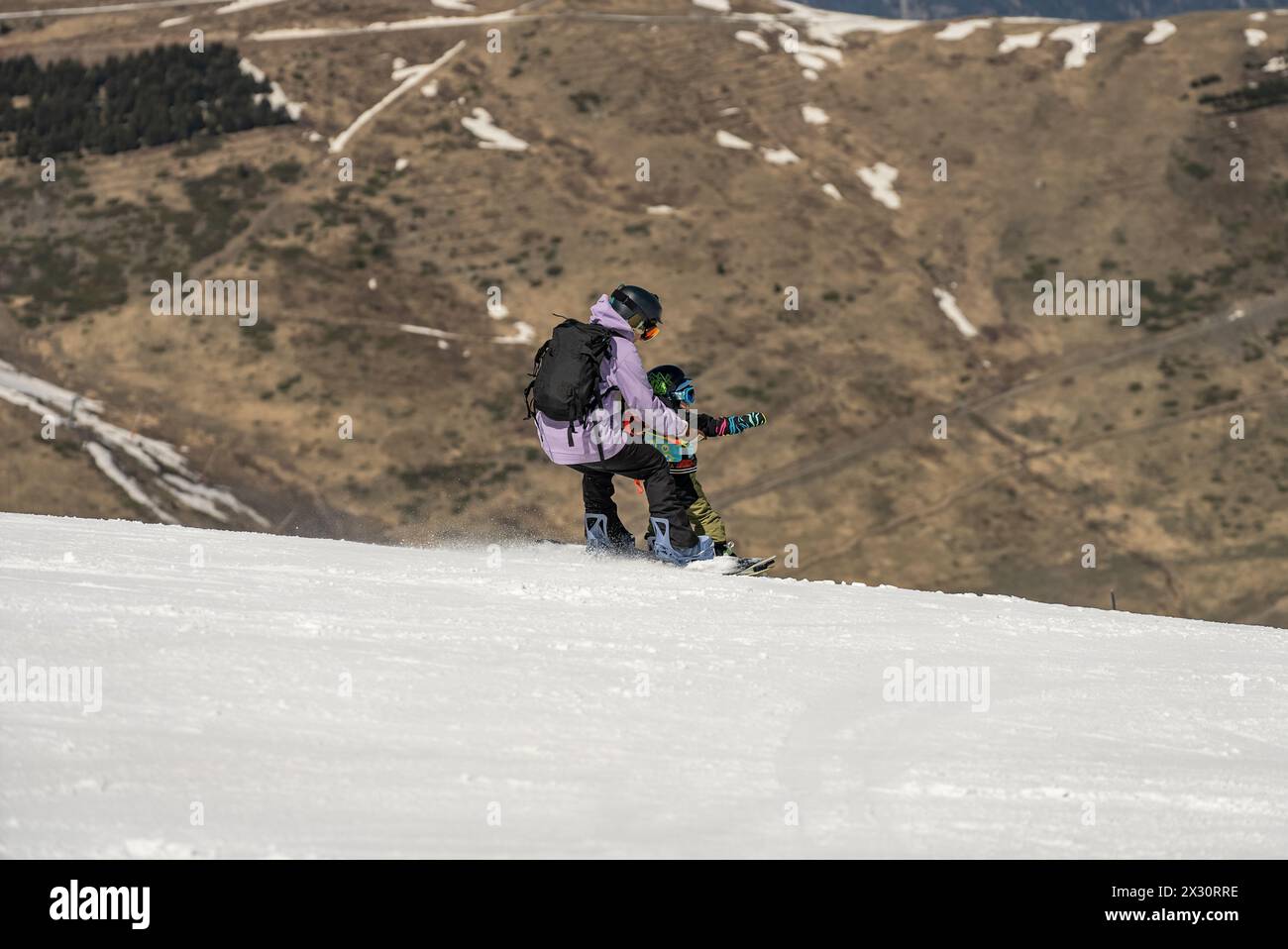 Kid with mom on snowboard. Learning snowboard little kid. Parent with ...