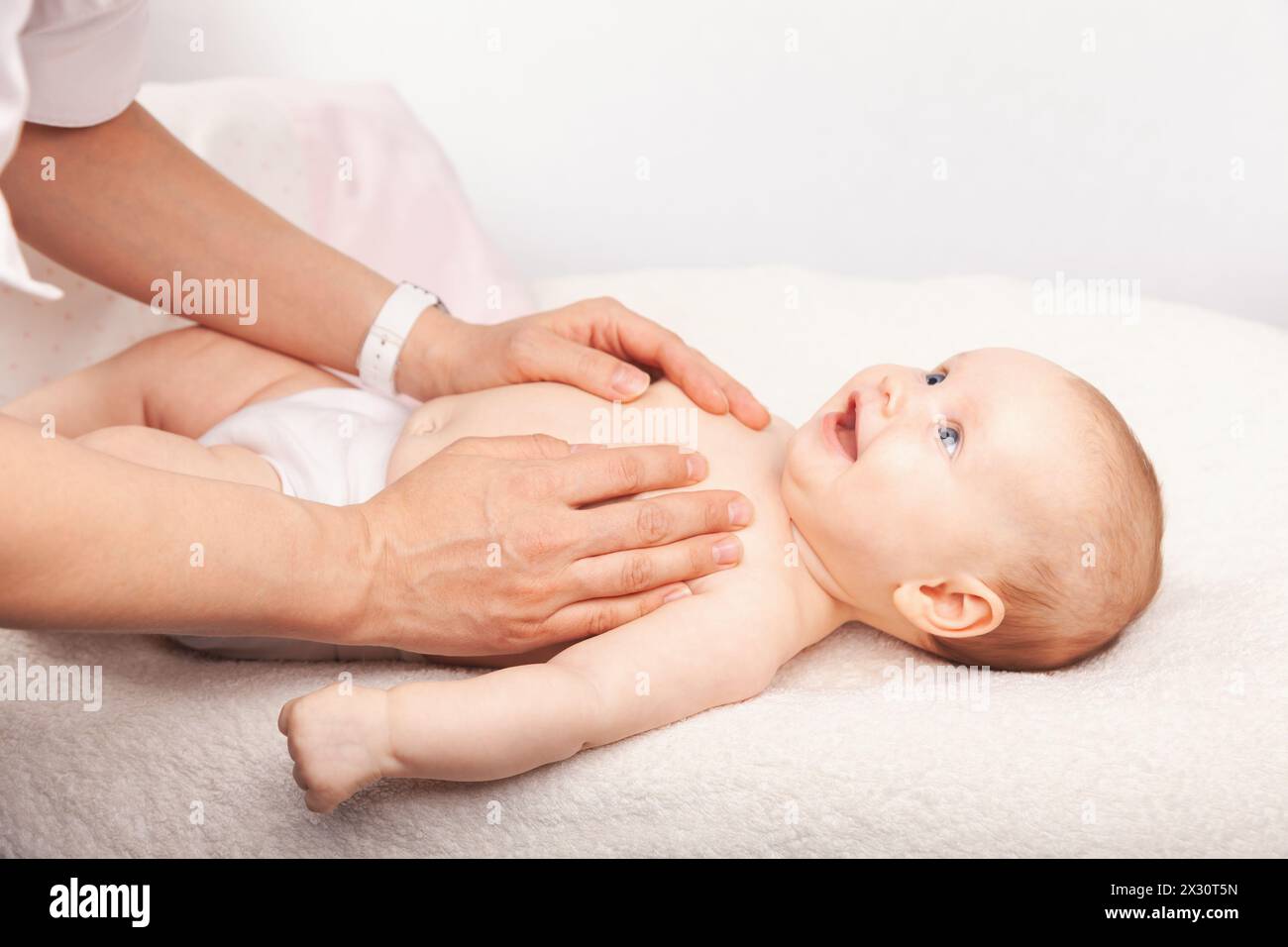 A caregivers hands are shown carefully providing a soothing chest ...