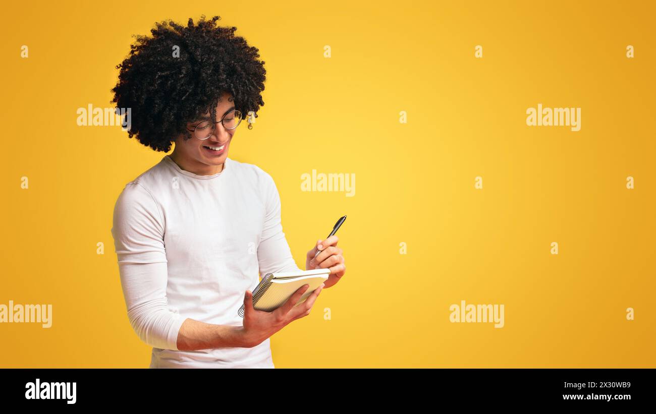 Cute african american millennial guy taking notes Stock Photo - Alamy