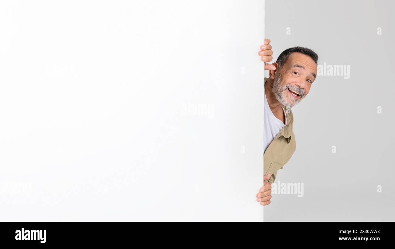Man Peeking Out From Behind White Wall Stock Photo - Alamy