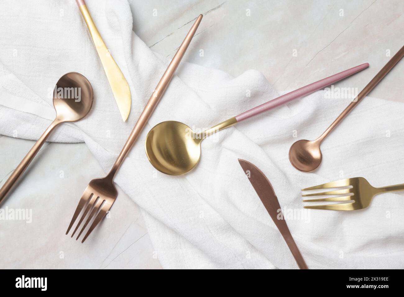Creative shot of golden cutlery on marble table, Design concept. Modern ...