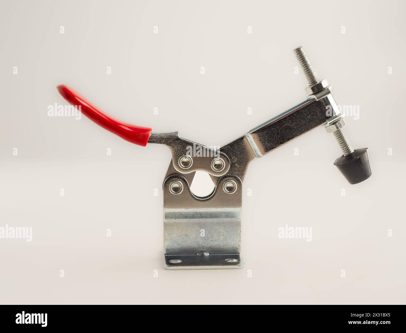 single Metal toggle clamp red lever, black rubber foot isolated on a ...