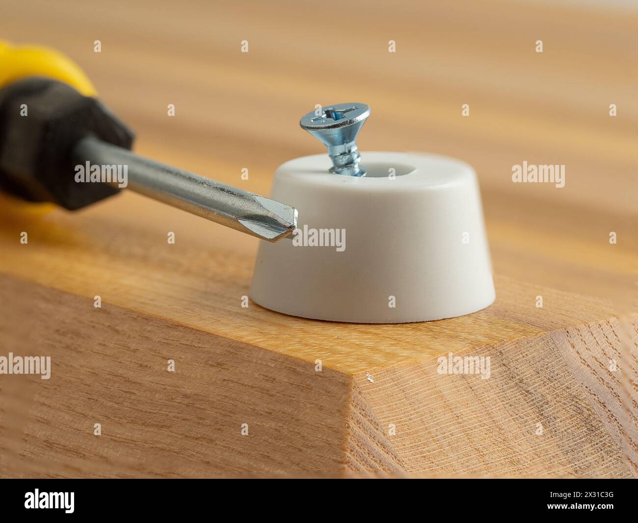 White plastic rubber bumper foot used for furniture being fitted with ...