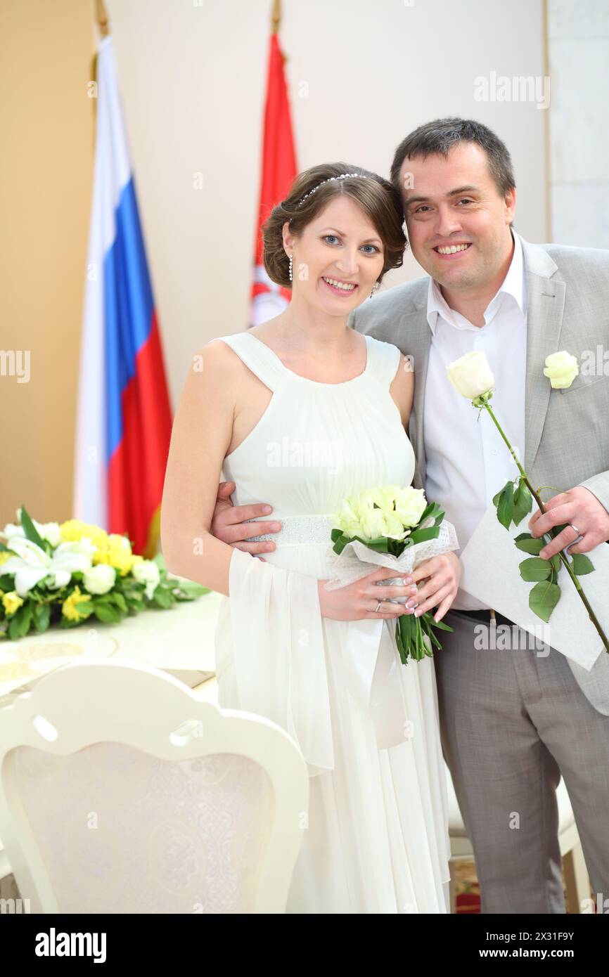 Happy beautiful bride and groom standing in the registry office, in the ...