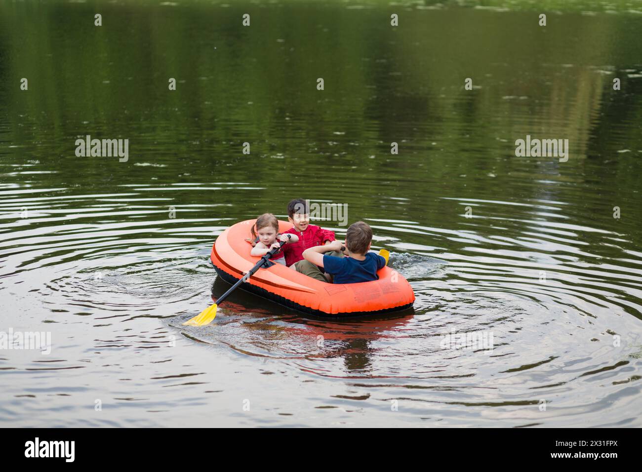 Three happy children floating in a rubber boat on the pond Stock Photo ...