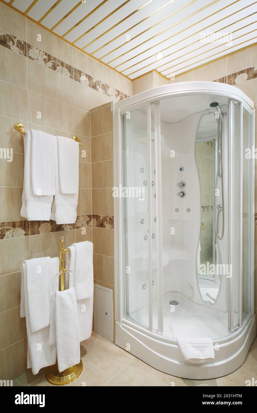 Clean bathroom with shower cabin and hangers with white towels Stock ...