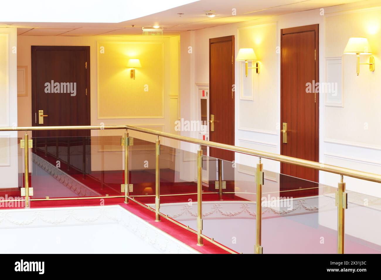 Wooden doors near indoor balconies with gilded handrails in hotel Stock ...