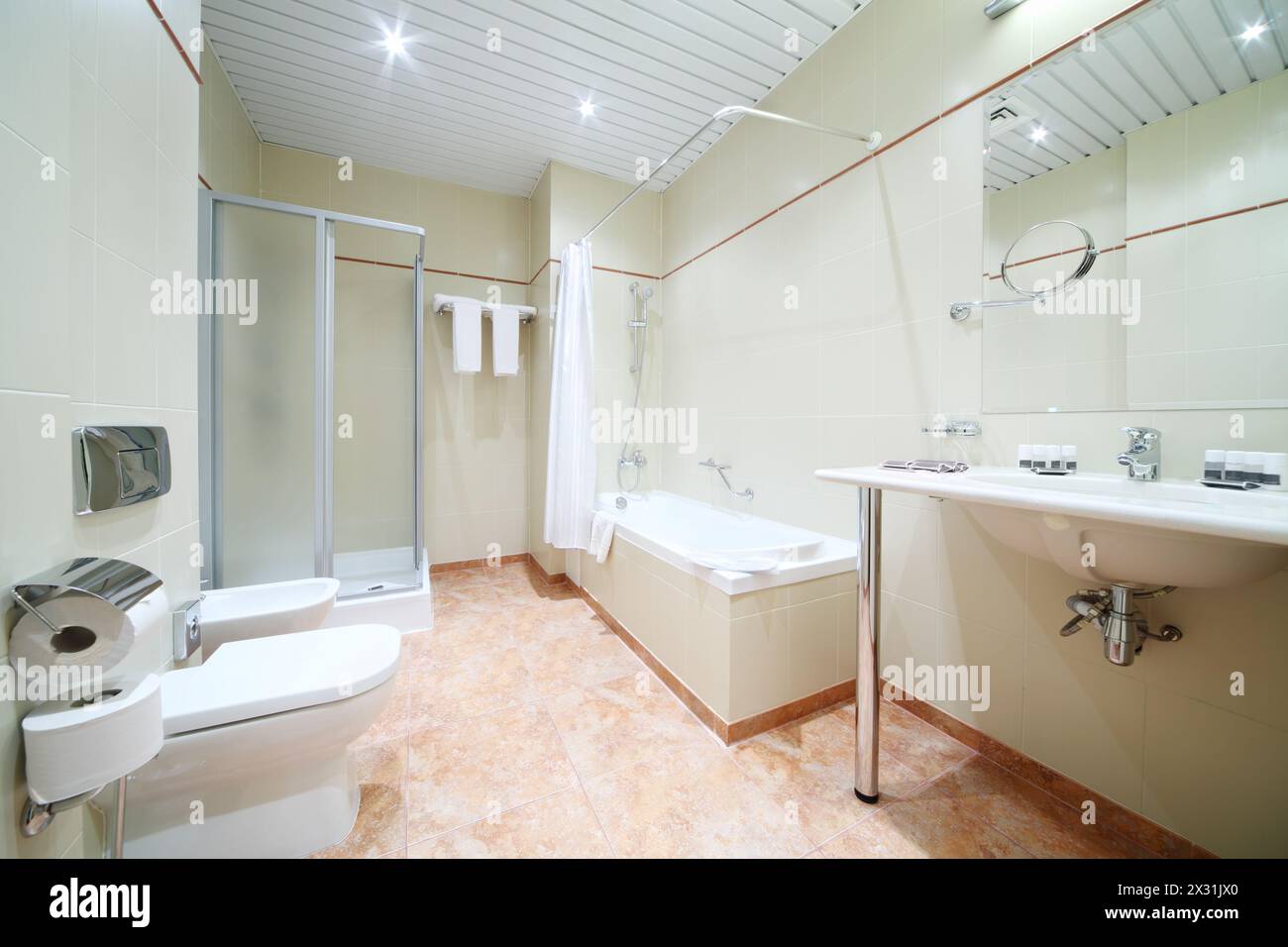 Light and empty bathroom with white bath, toilet and shower cabin Stock ...