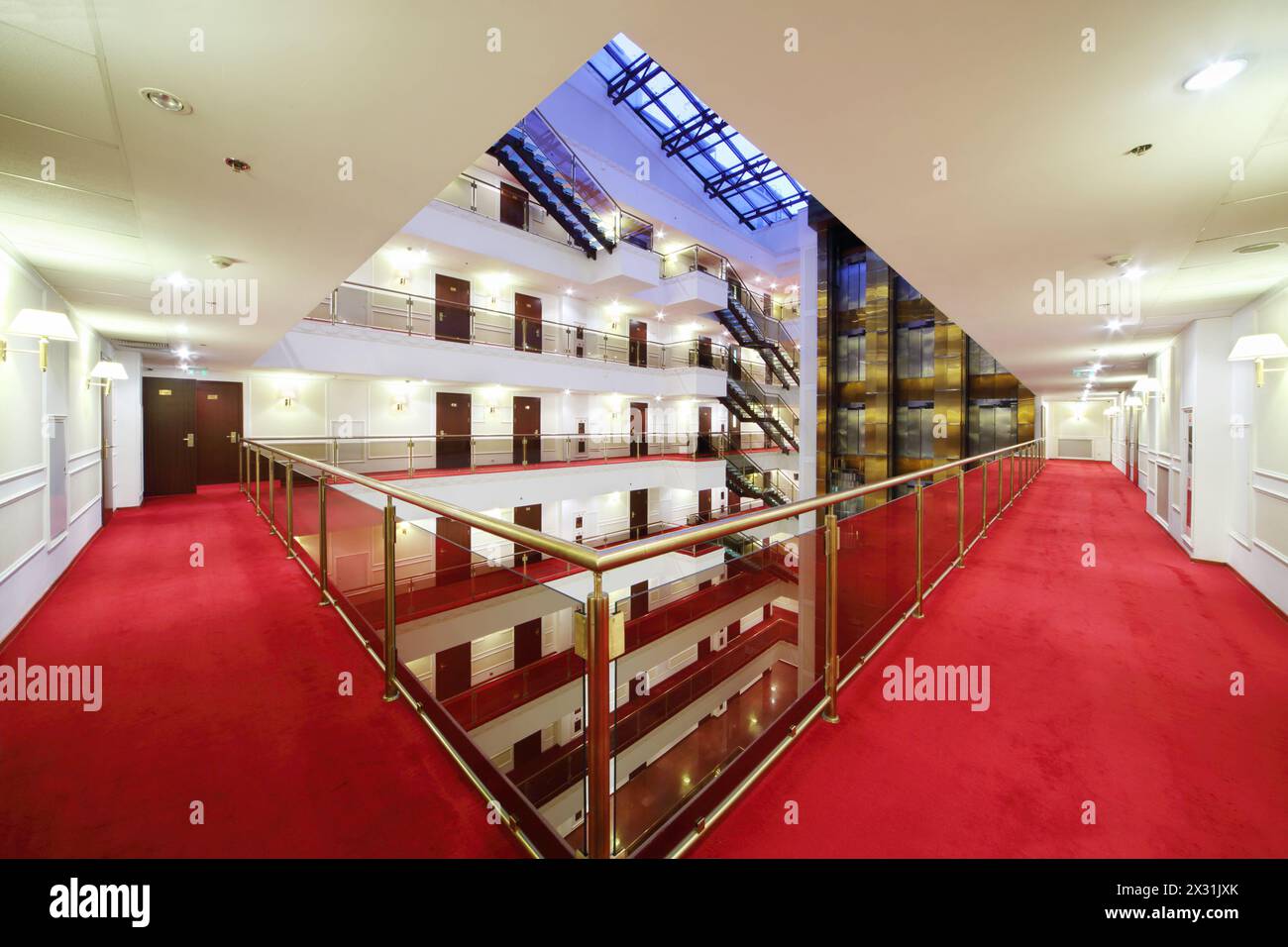 Floor with handrails, red carpet and doors to rooms in big modern hotel ...