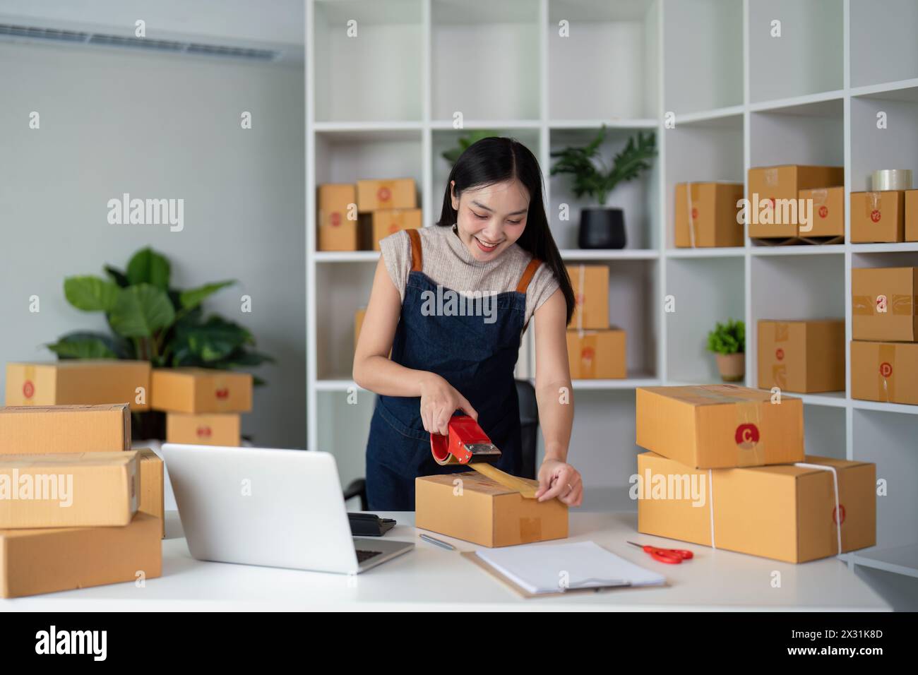Woman asian use scotch tape to attach parcel boxes to prepare goods for ...