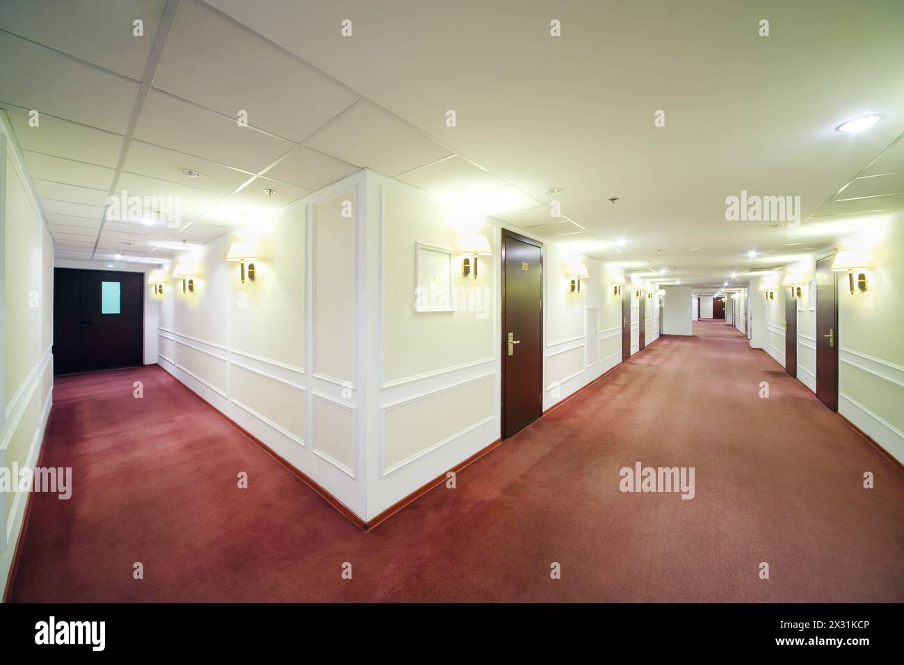Two spacious light hallways with many wooden doors to hotel rooms Stock ...