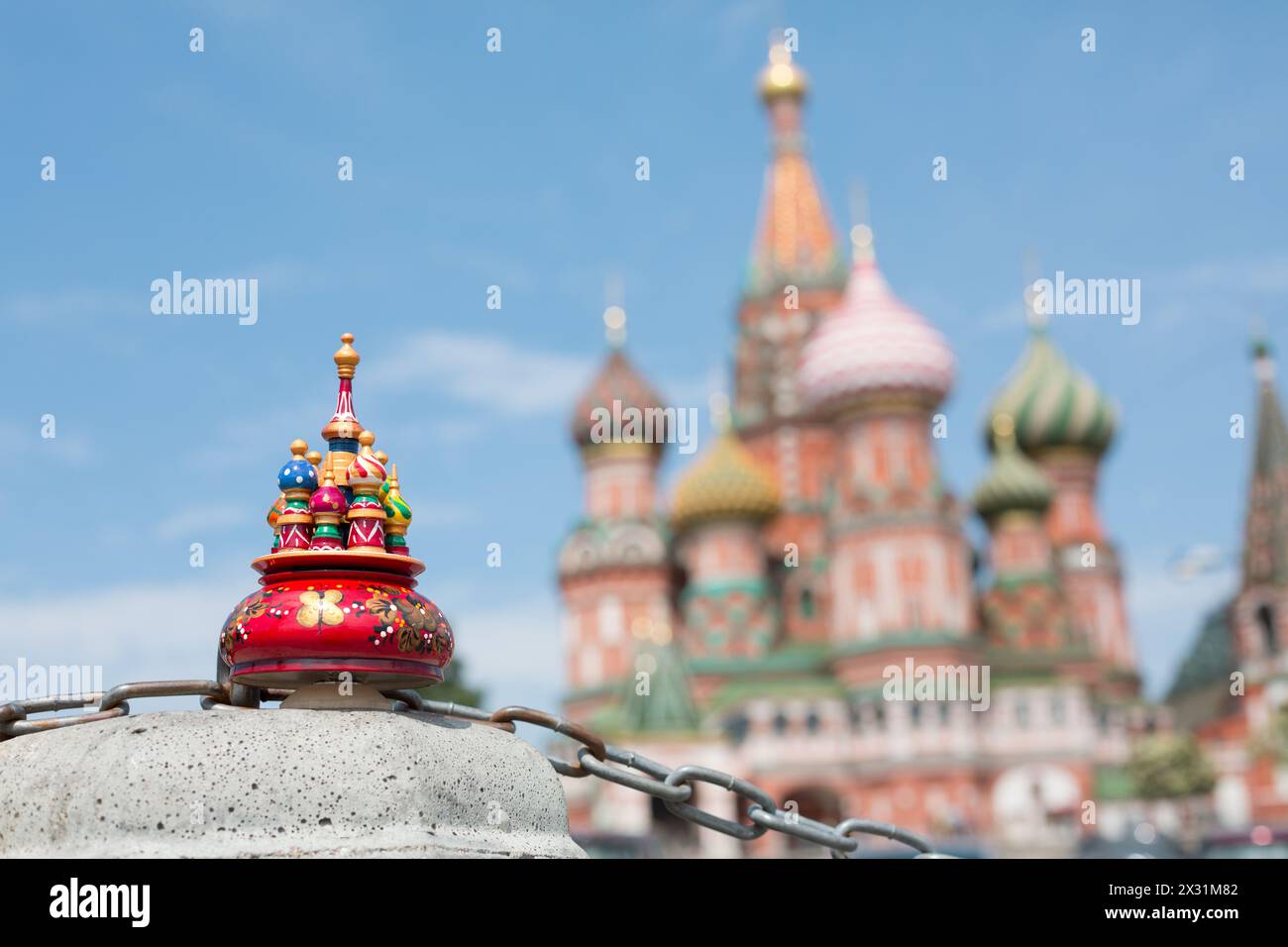 Toy miniature cathedral stands on concrete against the Saint Basils ...