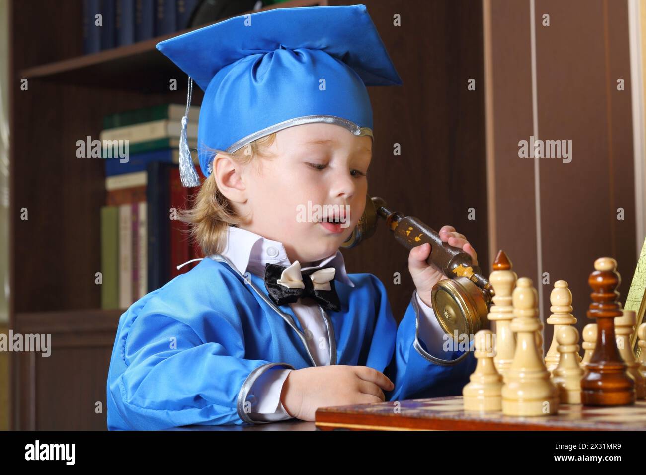 A boy talking on the phone while playing chess Stock Photo - Alamy