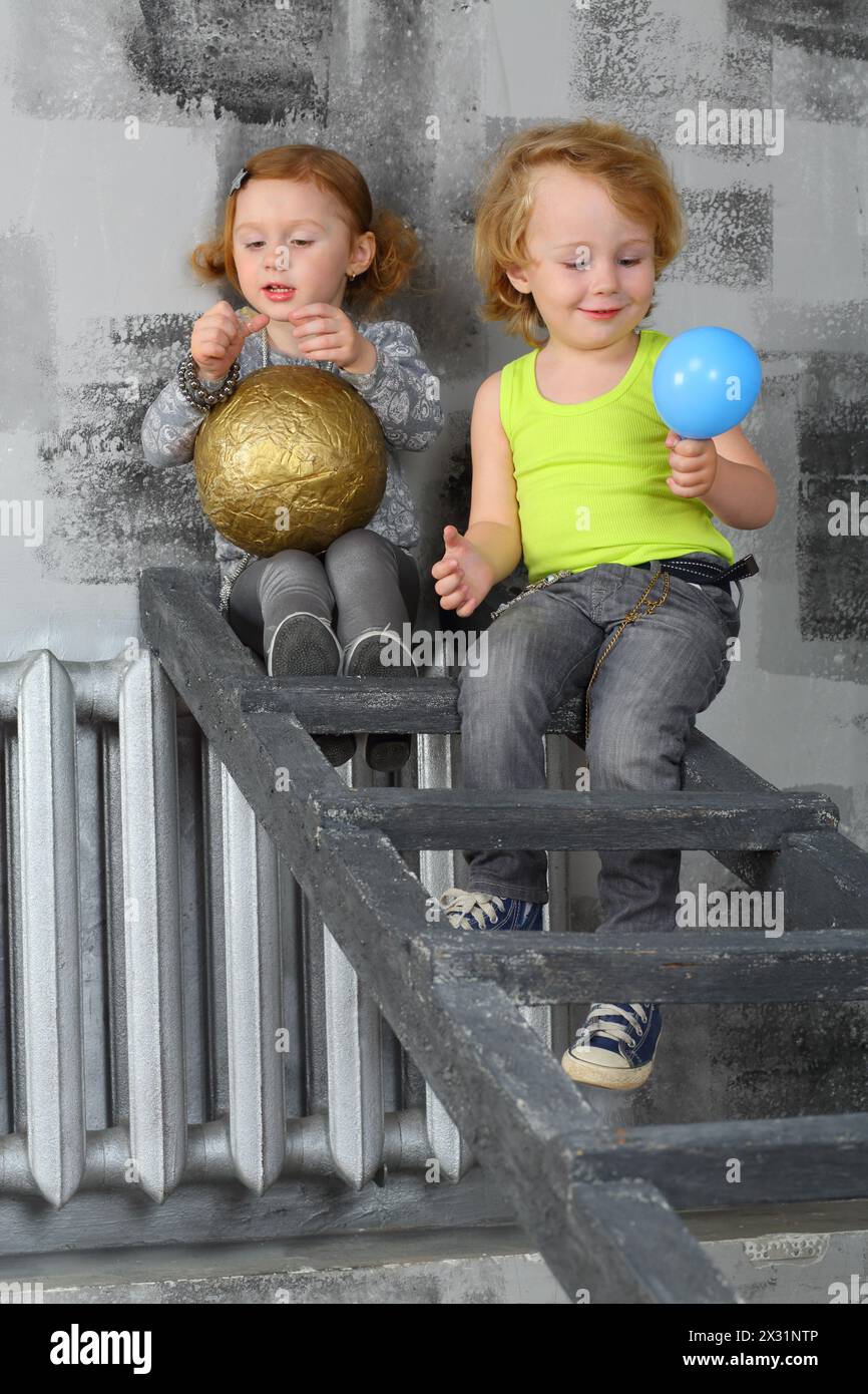 Little boy and girl sitting on a ladder with balloons Stock Photo - Alamy