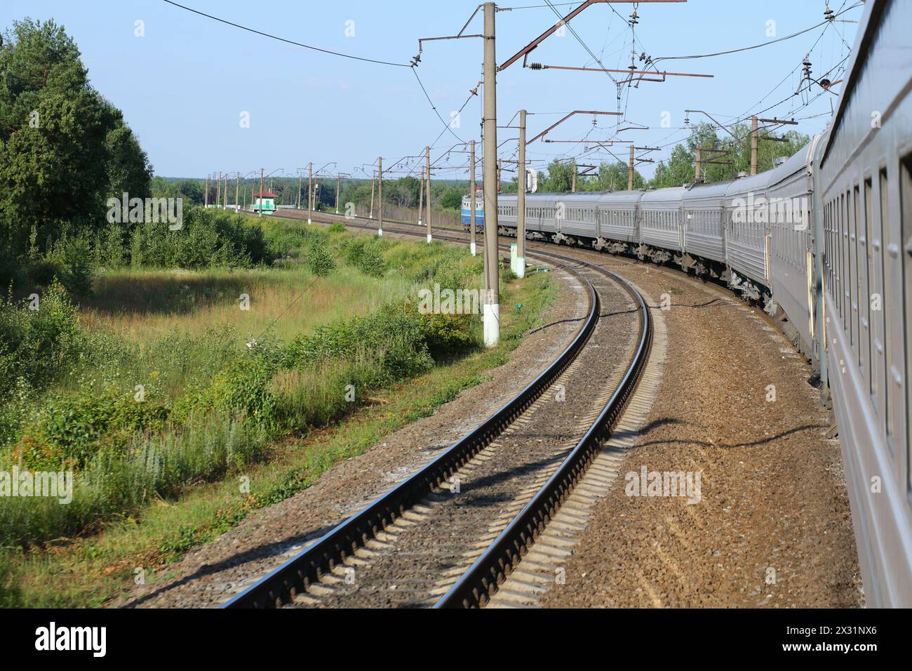 Gray passenger train turning on the railroad in the forest Stock Photo ...