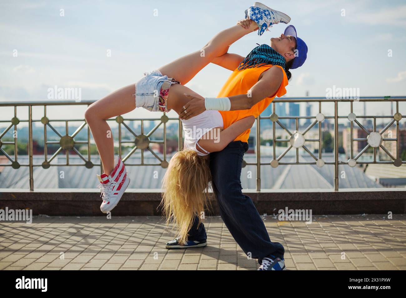 Beautiful couple doing acrobatic stunts in the street dance Stock Photo ...