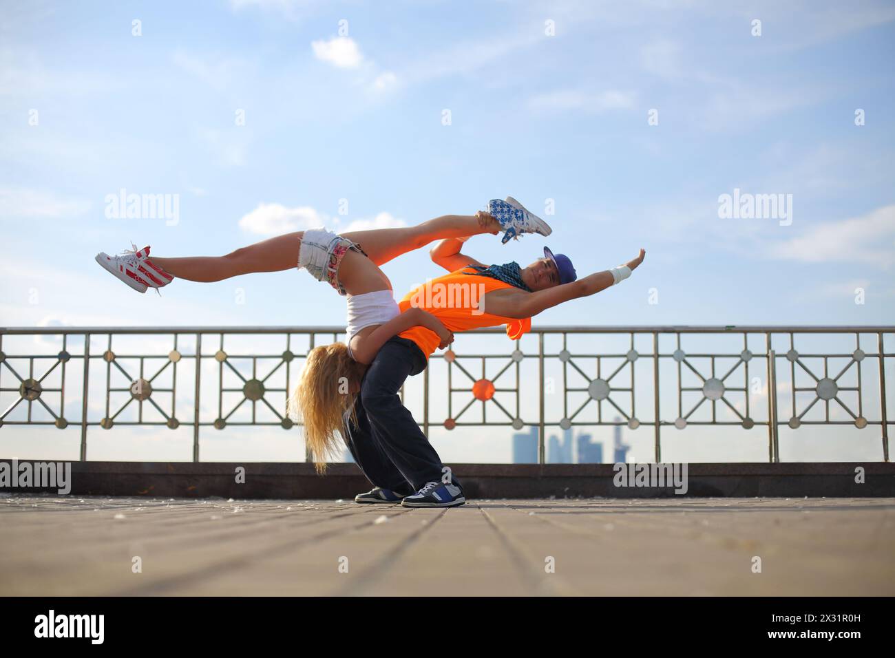 Young couple dancing modern dance in the street, girl do the splits ...