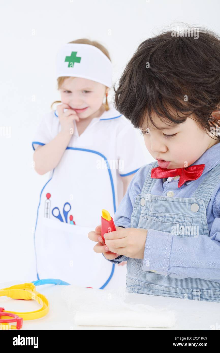 Little boy plays with toy medical instruments and girl looks at he on ...