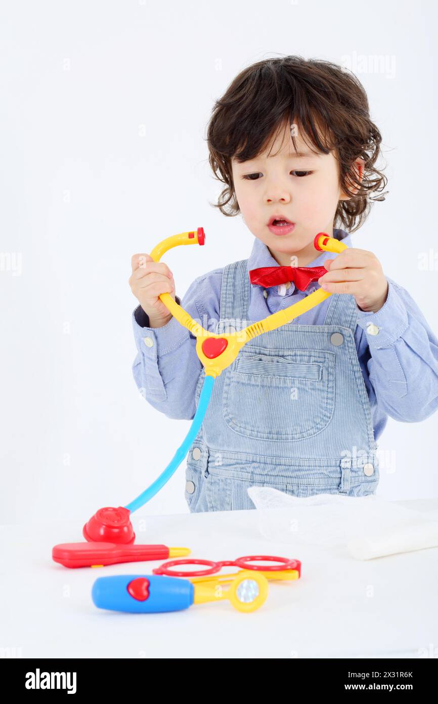 Little boy plays with toy phonendoscope and medical instruments on ...