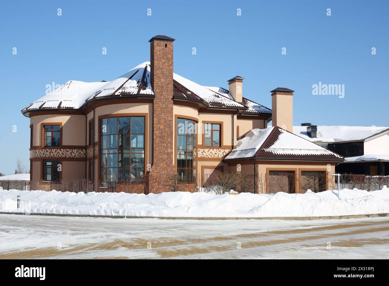Modern rounded cottage with long chimneys at frosty and sunny winter ...