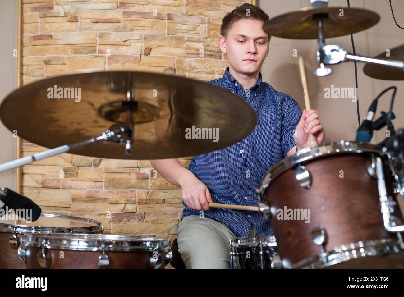 The young drummer plays the drum kit in the studio Stock Photo - Alamy