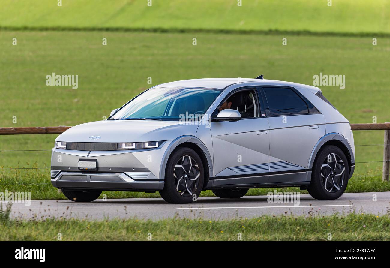 Ein silberner Hundai Ionic 5 fährt auf einer Strasse ausserorts im ...