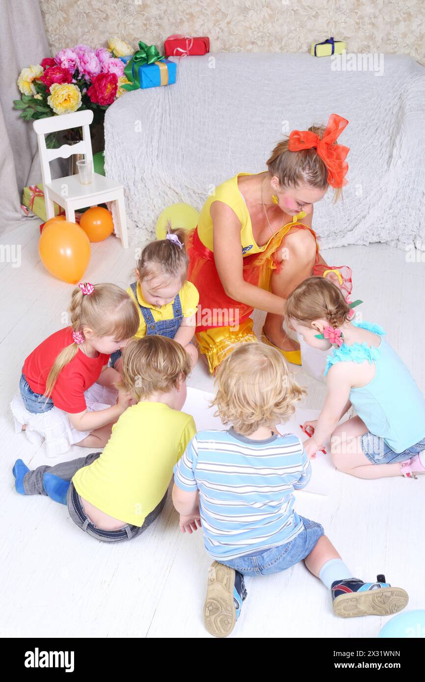 Five little kids and holiday representative draw at children party ...